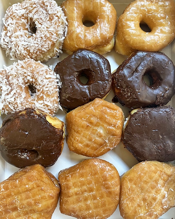 A box of possibilities. Chocolate, glazed, coconut, and cake&mdash;it's not just breakfast, it's an adventure in every bite.