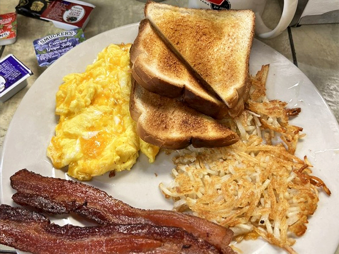 The breakfast trinity: perfect eggs, golden hash browns, crispy bacon. Add buttery toast and you've got the four horsemen of deliciousness.