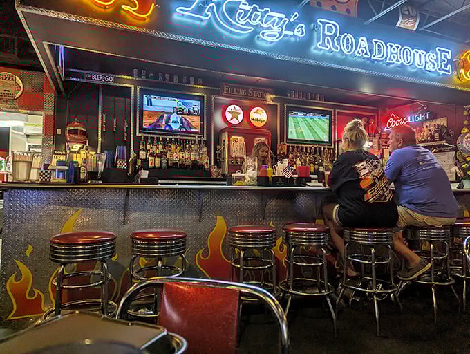 The bar area glows with neon promise, where flame-adorned stools and cold beers await those looking to unwind after a long Nebraska day. 