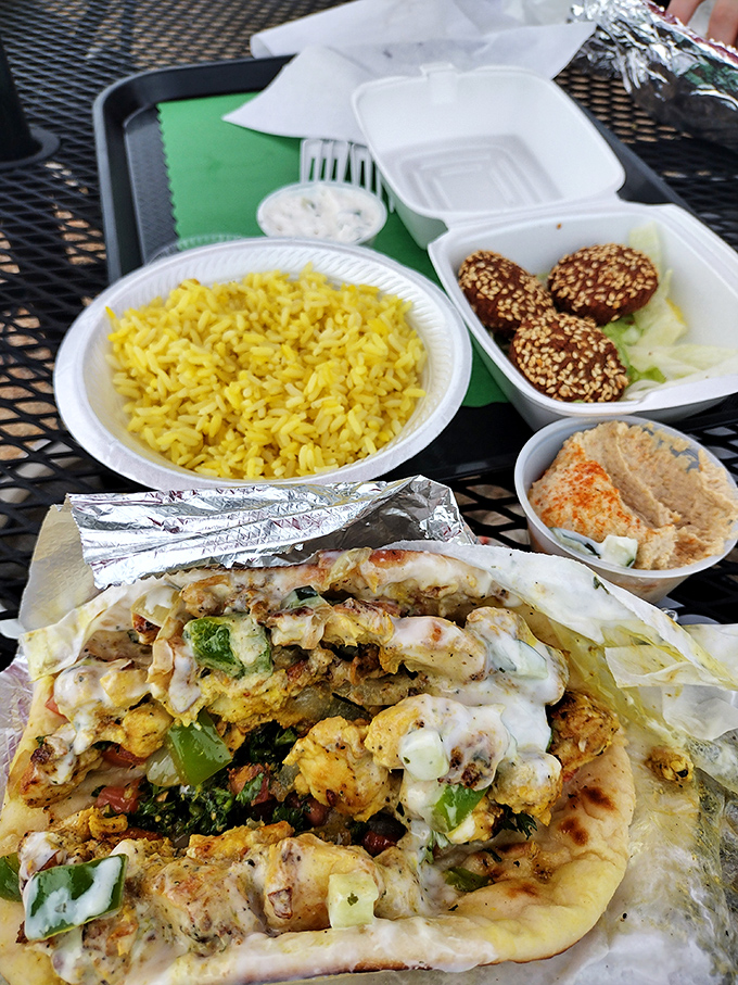 A feast fit for a philosopher—yellow rice, hummus, and a chicken wrap that's been kissed by Mediterranean sunshine and spices.