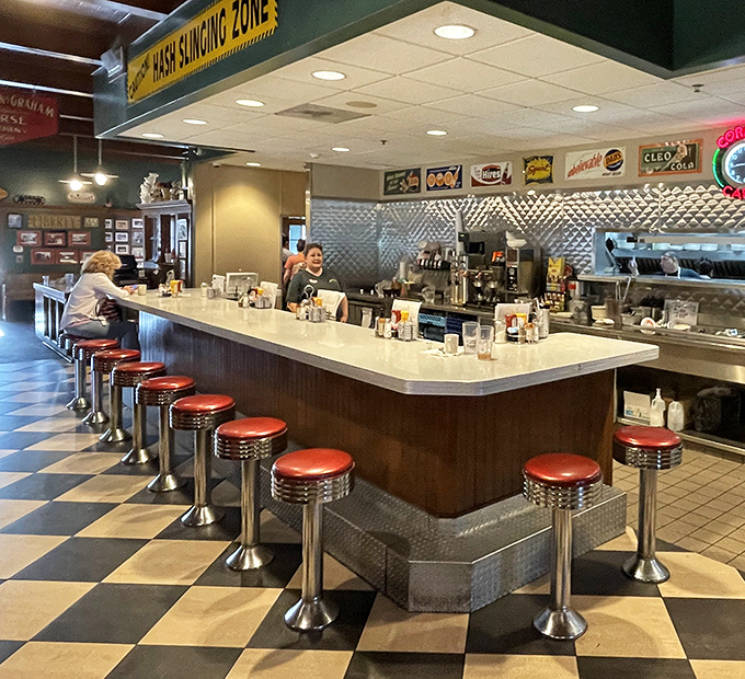 The counter seating&mdash;where solo diners become regulars, and the "Hash Slinging Zone" sign warns you're about to witness breakfast artistry.