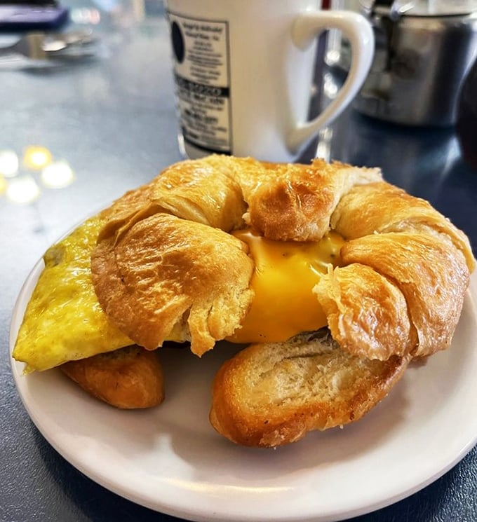 Breakfast architecture at its finest&mdash;a golden croissant sandwich where the egg takes center stage while toast plays a supporting role.