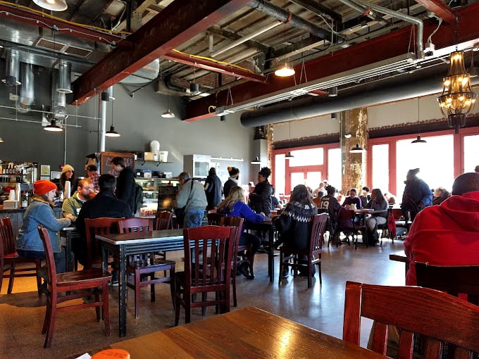 The bustling heart of Red Emma's where strangers become friends over shared tables and the collective hum of community in action.