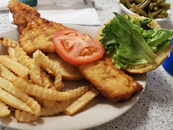 The money shot &ndash; that perfectly fried fish hanging off the bun, the fresh lettuce and tomato adding color, and those fries standing at attention like golden soldiers.
