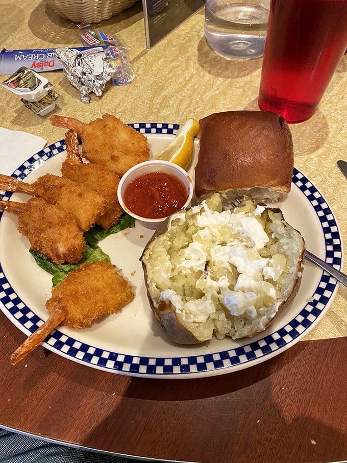 Golden-fried shrimp stand at attention next to a fluffy baked potato that's been split open to reveal its steamy, butter-melted soul.