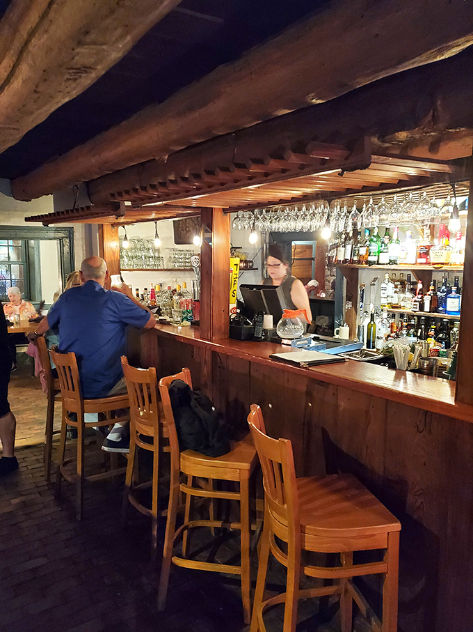 The bar's wooden beams and glasses hanging like crystalline stalactites create the perfect setting for swapping stories over perfectly crafted Old Fashioneds.