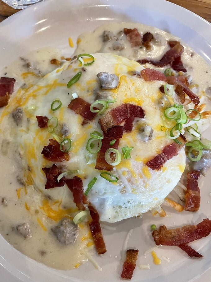 Breakfast decadence: a sunny-side egg atop a creamy sea, dotted with bacon islands. This dish doesn't just break the fast—it shatters it gloriously.