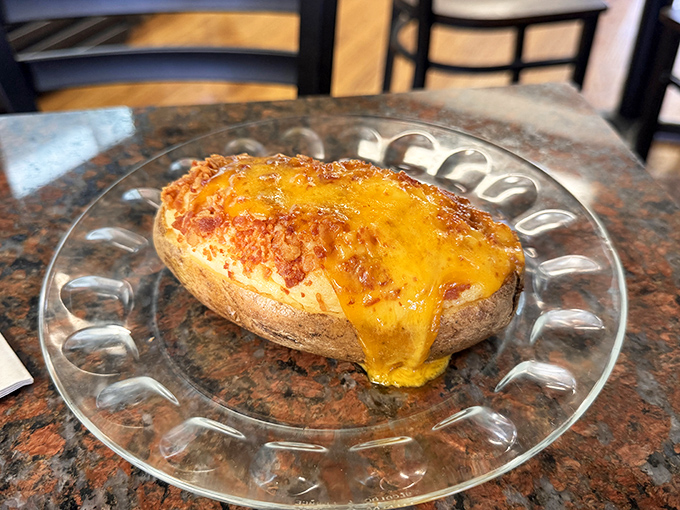 A loaded baked potato wearing a melted cheddar crown&mdash;proof that sometimes the simplest pleasures are actually the most magnificent.