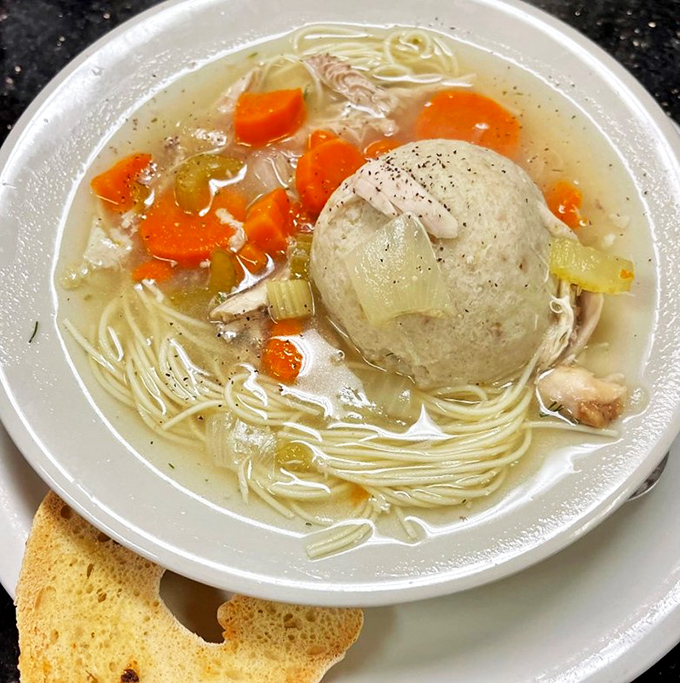 The matzo ball floating in this soup isn't just food&mdash;it's a perfect sphere of comfort, surrounded by thin noodles and vegetables like planets orbiting the sun.