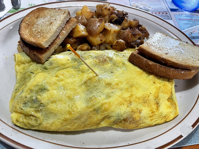A perfectly executed omelet that knows exactly what it's doing. Paired with golden home fries and toast, it's the breakfast equivalent of a standing ovation.