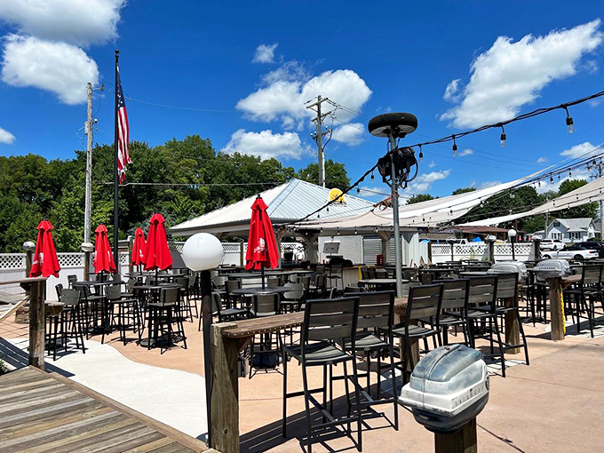 The outdoor deck where summer memories are made – red umbrellas standing at attention, ready for sunset views and lakeside laughter.