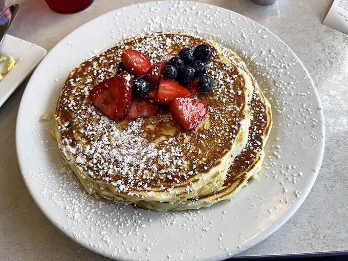 These pancakes wear their powdered sugar and berries like jewelry, proving that breakfast can indeed be the most glamorous meal of the day.