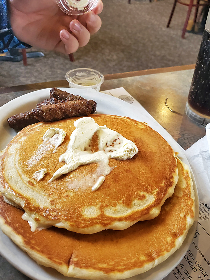 Pancakes so fluffy they practically hover above the plate, with a pat of butter slowly melting into breakfast perfection.