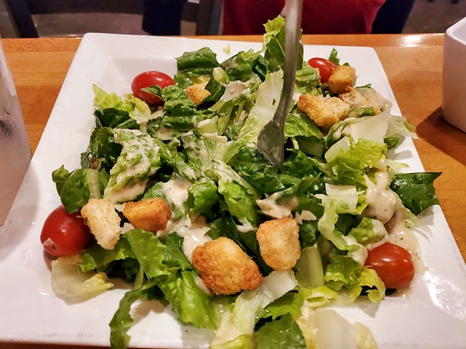 A Caesar salad that doesn't apologize for being the healthy option. Those croutons are doing important work between seafood courses.