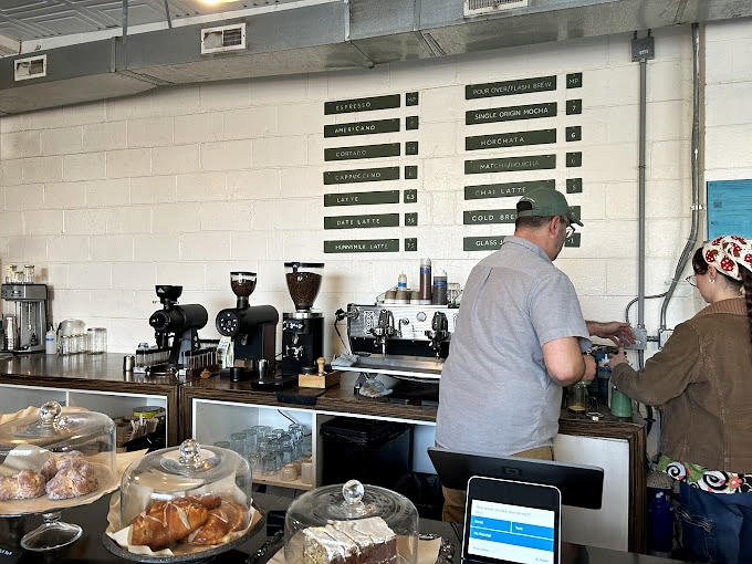 Behind the counter, coffee equipment that looks like it could power a small spacecraft, operated by baristas with the focus of brain surgeons.