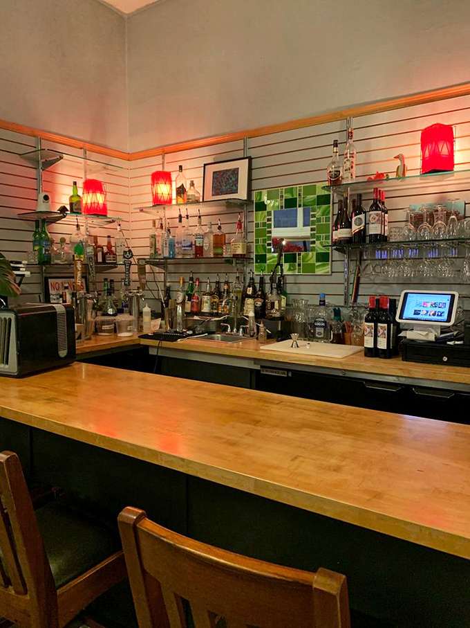 The bar area glows with warm light, offering liquid companions for your waffle adventure&mdash;because adulting has some perks after all.