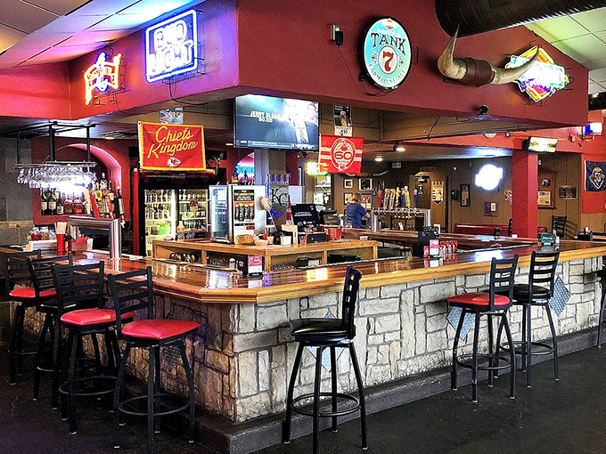 The bar area: where sports on TV and barbecue on plates create the perfect storm of contentment. Those neon signs aren't just decoration&mdash;they're beacons of hope.