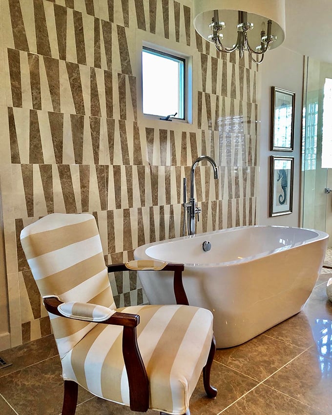 A bathroom vignette so stylish you might actually look forward to cleaning it. That striped chair invites you to linger with a good book and a glass of wine.