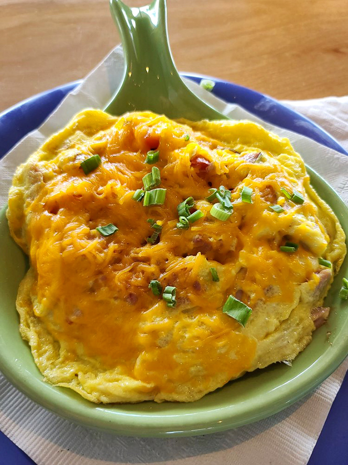 A cheesy omelet that spreads across the plate like a morning sunrise, promising that good things come to those who breakfast.
