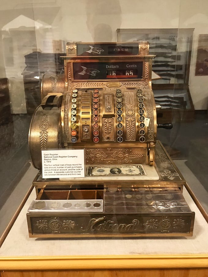 This ornate National cash register represents the commerce that flourished alongside America's growing automotive culture, a beautiful mechanical calculator.