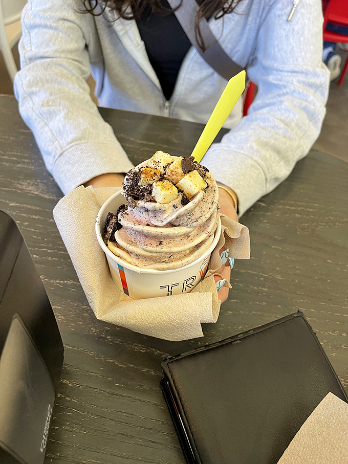 This creation isn't just held&mdash;it's cradled like the precious treasure it is, with toppings arranged like jewels in a crown of frozen custard.