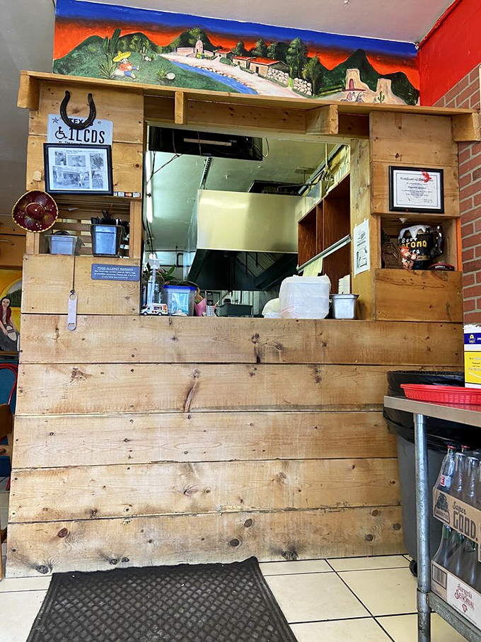 Behind this humble wooden counter, culinary magic happens. The kitchen window offers glimpses of the promised land where tacos are born.