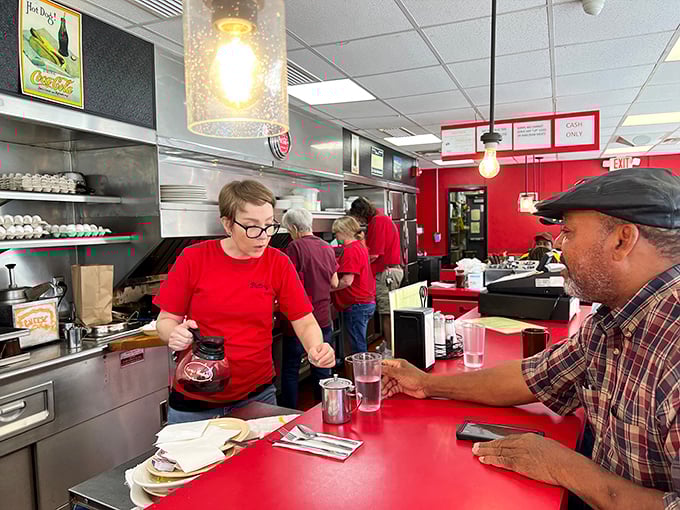 Wooden booths and red tables stand ready for the breakfast rush, while kitchen magic happens just beyond the counter.