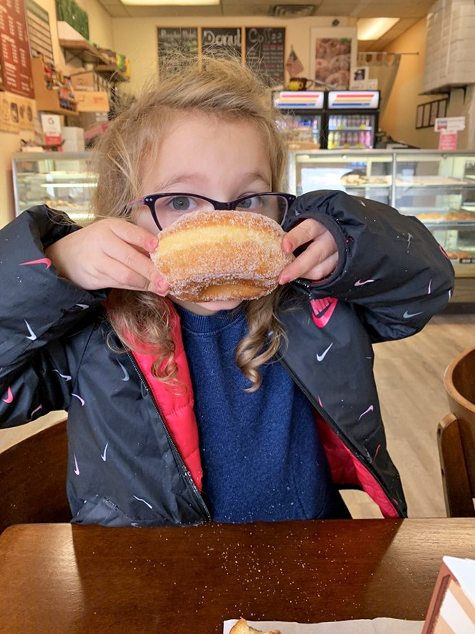 Future food critic in training discovers the universal truth&mdash;nothing brings pure joy quite like a sugar-dusted donut and sticky fingers.