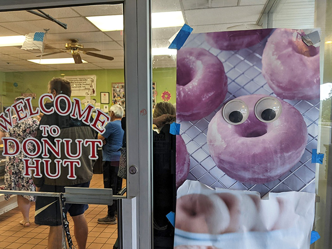 "Welcome to Donut Hut" indeed! Even the googly-eyed purple donut mascot seems to understand the gravity of the moment.