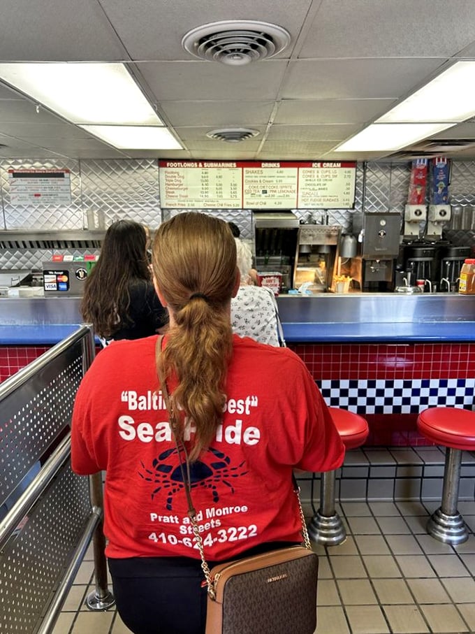 The back-of-head view every regular knows well: the anticipatory stance of someone about to experience a burger that's remained consistently delicious through fourteen presidencies.