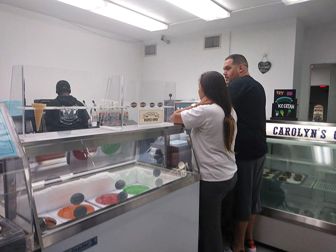 The sacred transaction: customers contemplating life-changing decisions while staff patiently awaits. "One scoop or two?" is never just a simple question.