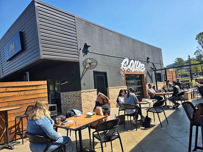 The outdoor patio scene: where coffee meets sunshine. These aren't just tables&mdash;they're community gathering spots disguised as furniture.