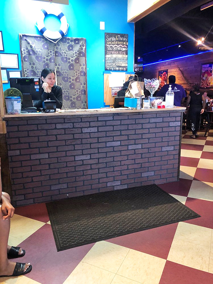 Checkered floors and bright blue walls create a welcoming space where strangers become friends, united by shellfish and satisfaction.