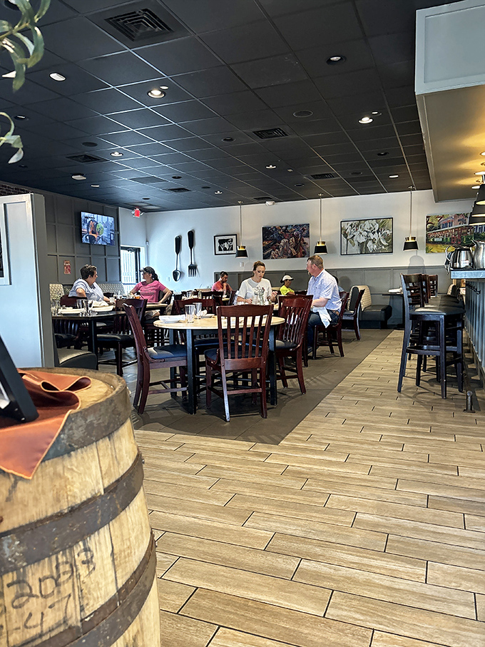 A snapshot of happiness: diners gathered around wooden tables, creating memories between bites. The barrel in the foreground hints at the establishment's appreciation for well-aged things.