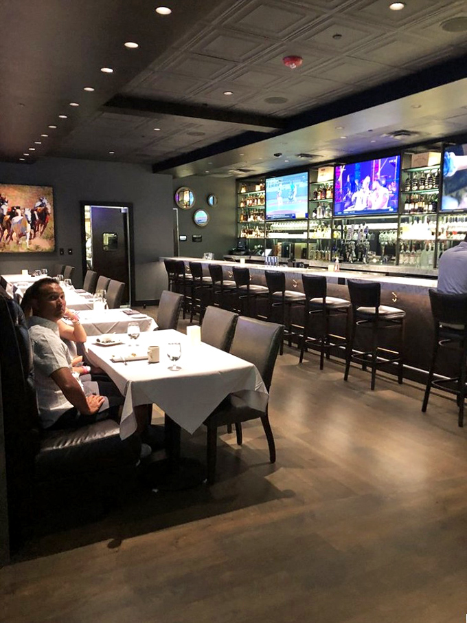 The bar area balances white tablecloths with televisions, proving Oklahoma knows how to combine refinement with sports-watching practicality.
