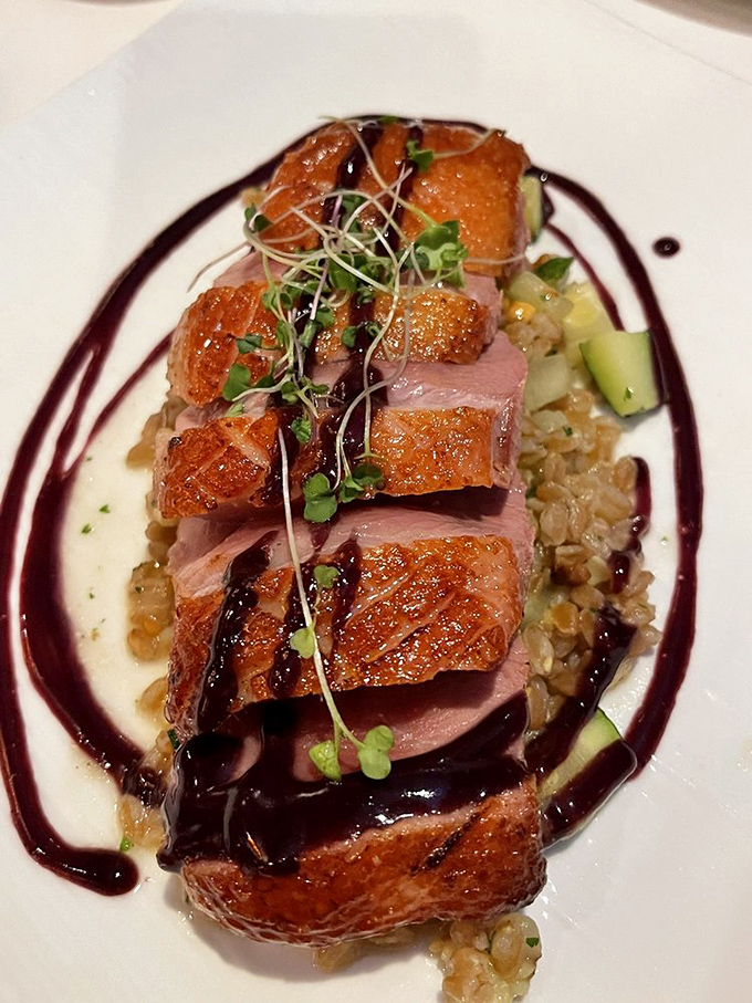 Duck breast sliced to reveal that perfect rosy center, arranged over grains with a sauce so good you'll consider drinking it.
