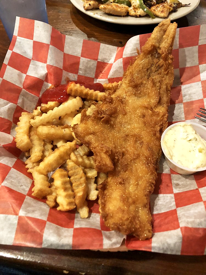Golden-battered fish that shatters with each bite, served with crinkle-cut fries that were clearly born to swim in ketchup.