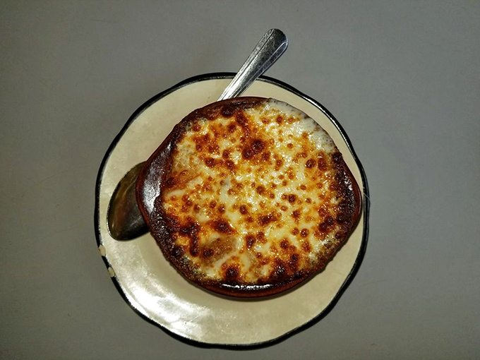 French onion soup with a cheese cap so perfectly browned, it deserves its own Broadway show. Standing ovation guaranteed.