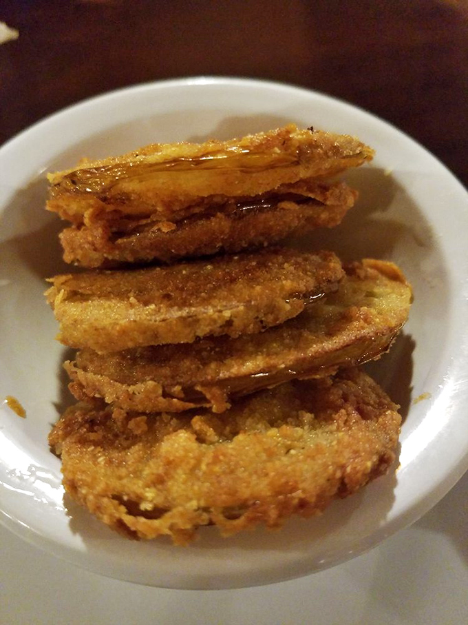 Fried green tomatoes stacked like golden coins, drizzled with syrup. Crispy, tangy treasures that disappear faster than you'd expect.