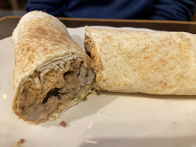 Wrapped perfection that fits in one hand. This shawarma wrap reveals its treasure of seasoned meat and veggies&mdash;portable Mediterranean bliss.