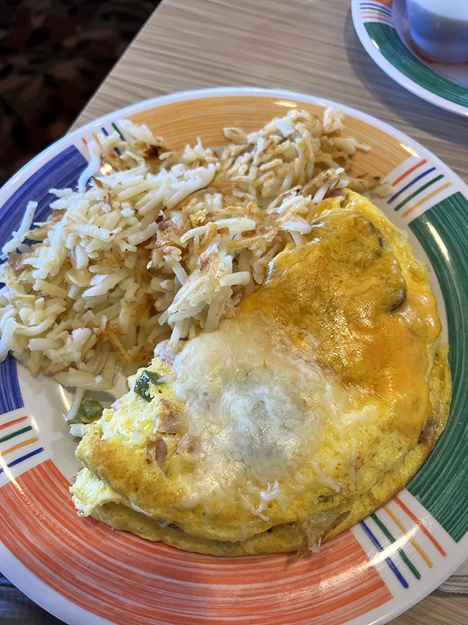 An omelet that knows its purpose in life is to be fluffy, flavorful, and flanked by a mountain of perfectly crisped hash browns.