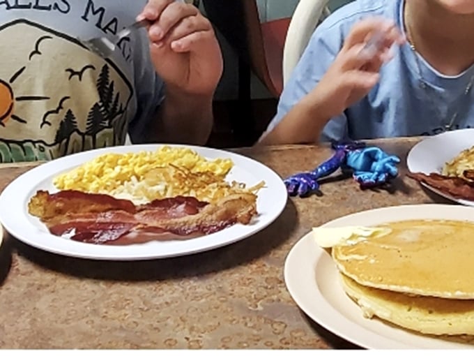 Breakfast doesn't get more honest than this: golden pancakes, scrambled eggs, and bacon that makes you question why you'd eat anything else.