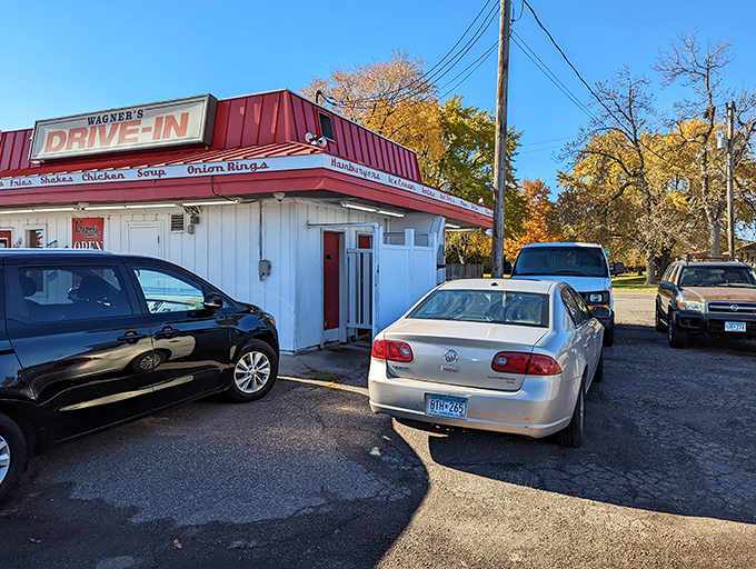 Cars gather like hungry metal beasts around this humble shrine to roadside dining, their drivers united by the universal quest for the perfect burger.