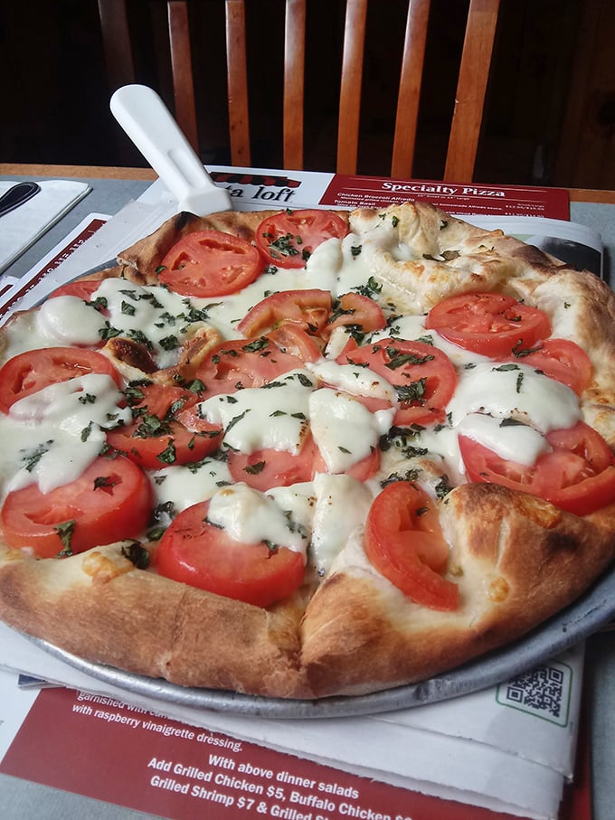 A margherita pizza that celebrates simplicity &ndash; fresh tomatoes, basil, and mozzarella proving that less is more when ingredients are quality.
