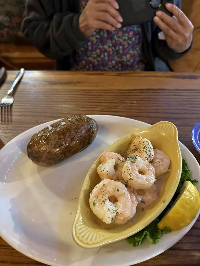 Butterfly shrimp nestled in their boat-shaped dish, sailing alongside a baked potato island&mdash;a seafaring adventure for your taste buds.