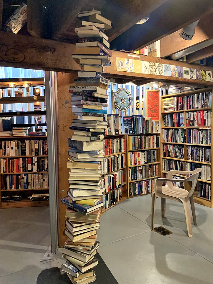 A gravity-defying tower of books stands like a literary sculpture. Physics and literature finding perfect balance in this precarious column.