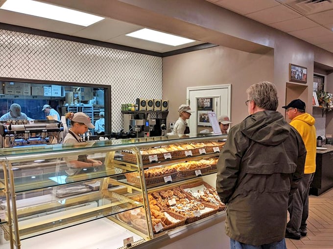 Behind the scenes, pastry artisans work their magic while customers contemplate life-changing decisions like "one of each or two of favorites?"