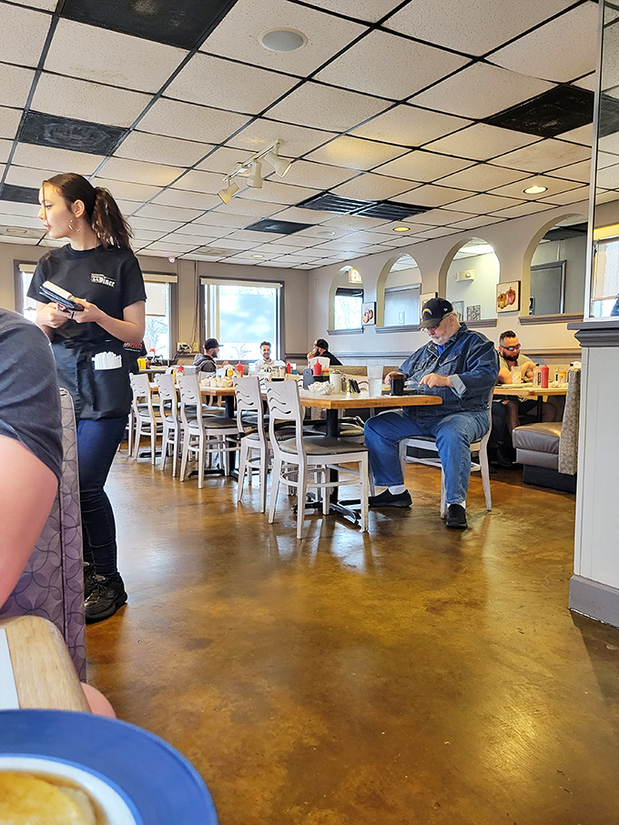 The staff moves with practiced efficiency, carrying plates and stories with equal ease. True diner professionals at work.
