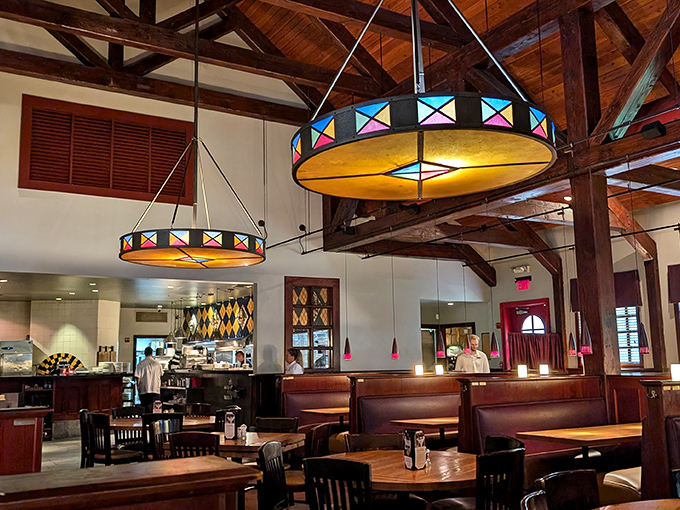 Stained glass pendant lights cast a warm glow over wooden tables, creating that perfect ambiance where memories are made between bites.