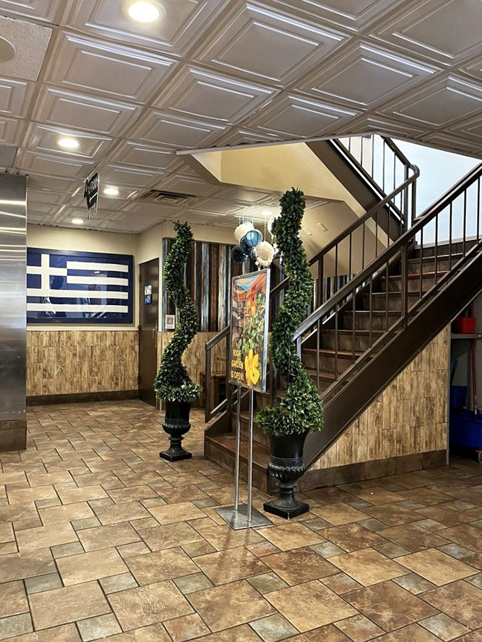The staircase to second-floor seating, flanked by greenery and Greek flags&mdash;like ascending Mount Olympus, if Mount Olympus smelled deliciously of gyros.
